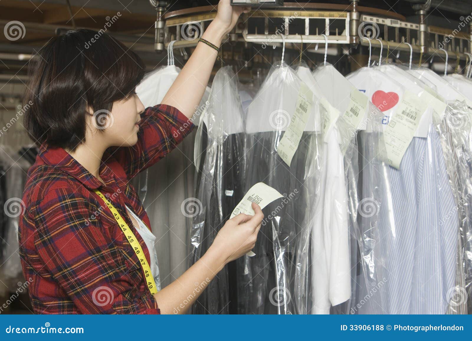 Laundry Owner Reading Receipt by Clothes Rail Stock Photo - Image of ...
