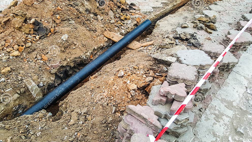 Laying Installation of a New Cable in a Plastic Pipe. Digging Drilling ...