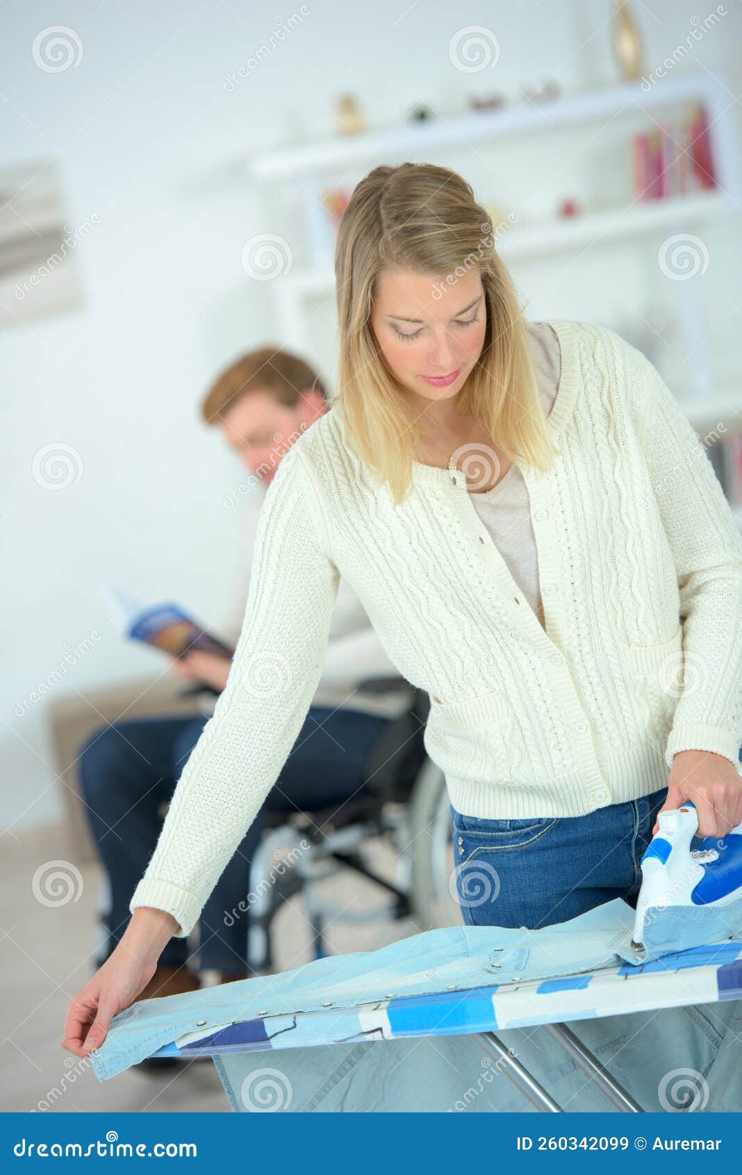 Lazy Boyfriend on Couch while Girlfriend Irons Stock Image - Image of ...