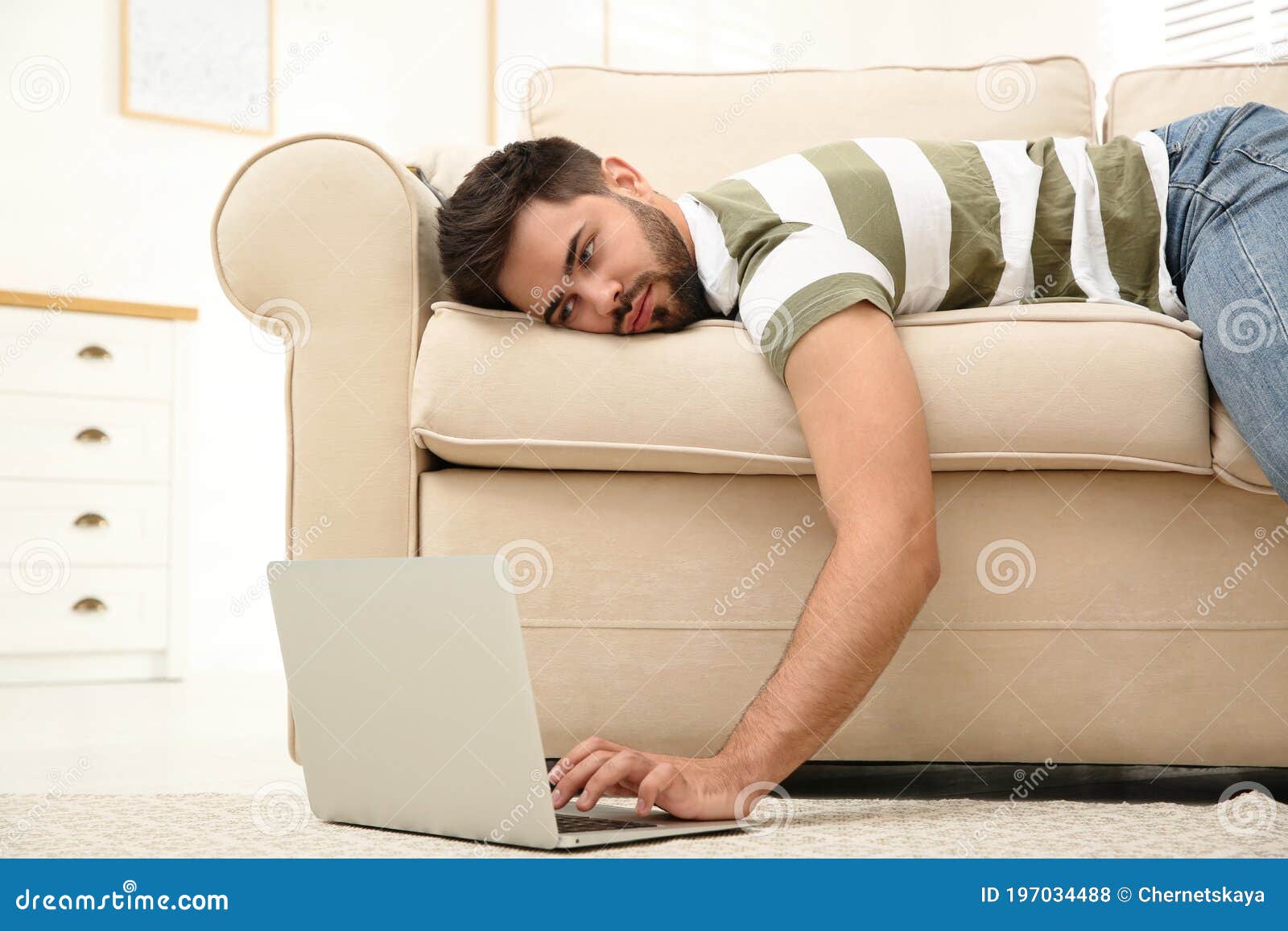 Lazy Young Man Using Laptop while Lying on Sofa at Home Stock Photo ...