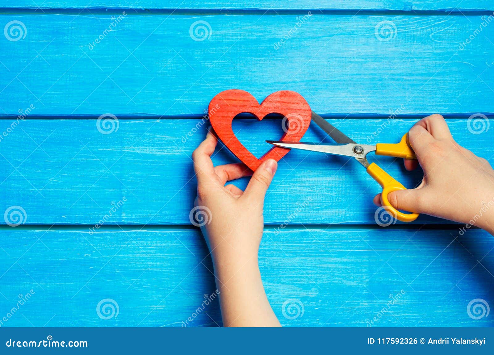 Le Mani Femminili Hanno Tagliato Un Cuore Rosso Di Legno Con Le Forbici ... Le Mani Femminili Hanno Tagliato Un Cuore Rosso Di Legno Con Le Forbici ...
