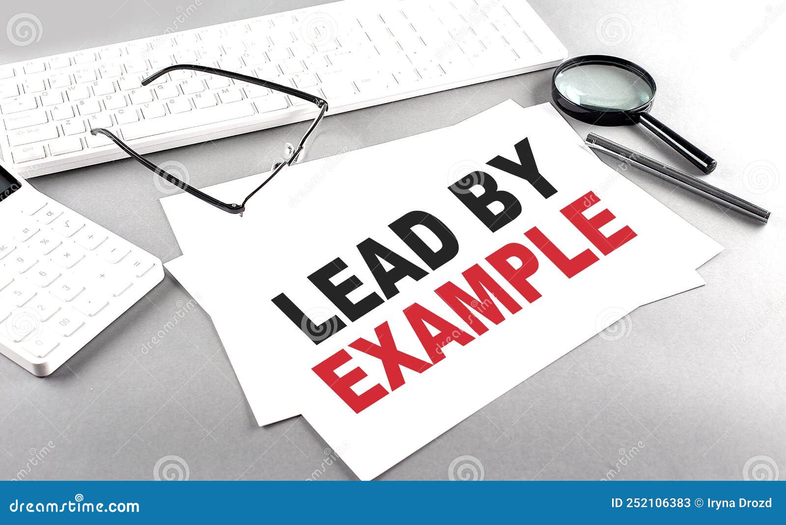 LEAD by EXAMPLE Text on a Paper with Keyboard, Calculator on Grey ...