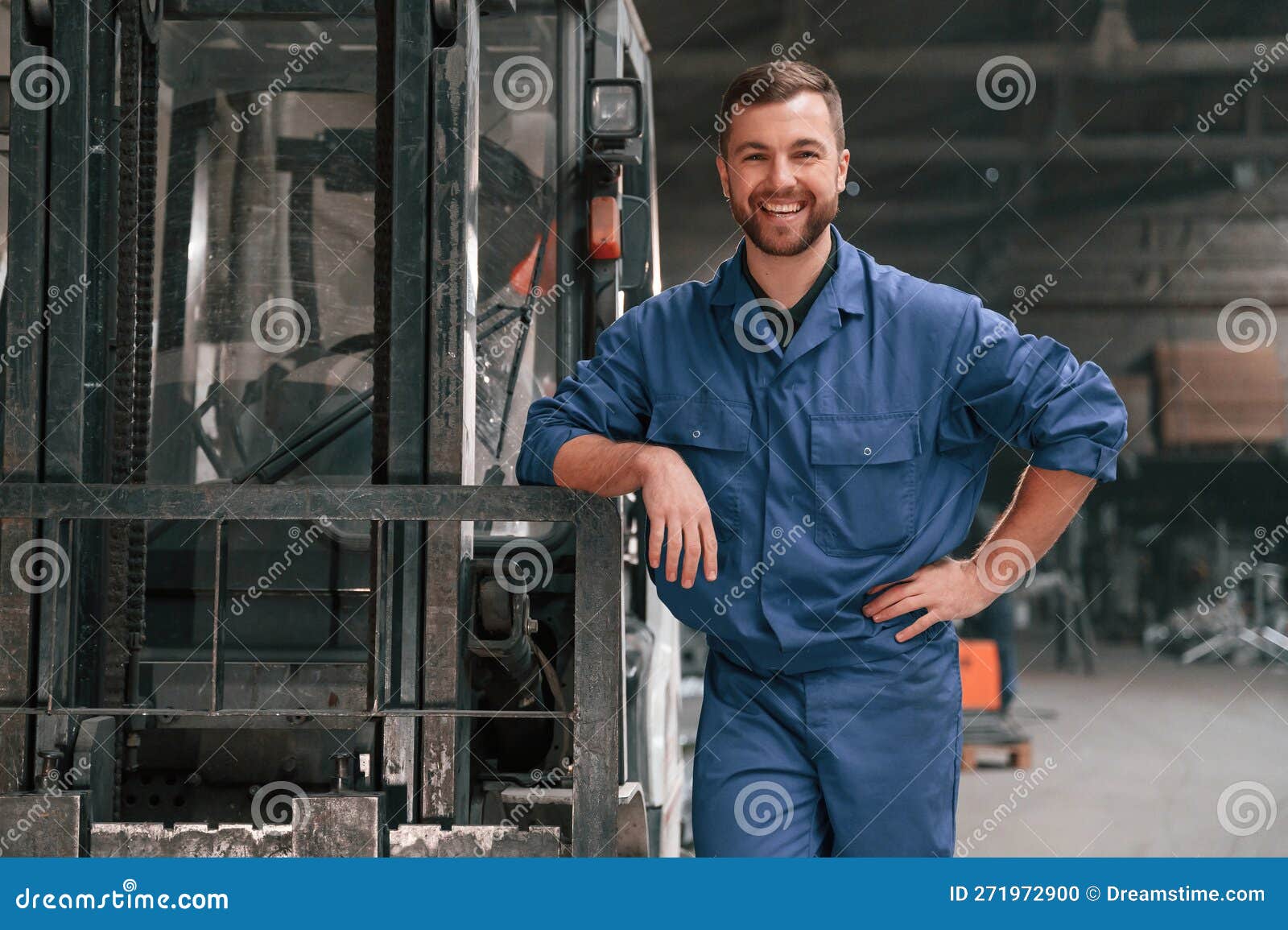 Leaning on the Forklift. Factory Worker in Blue Uniform is Indoors ...