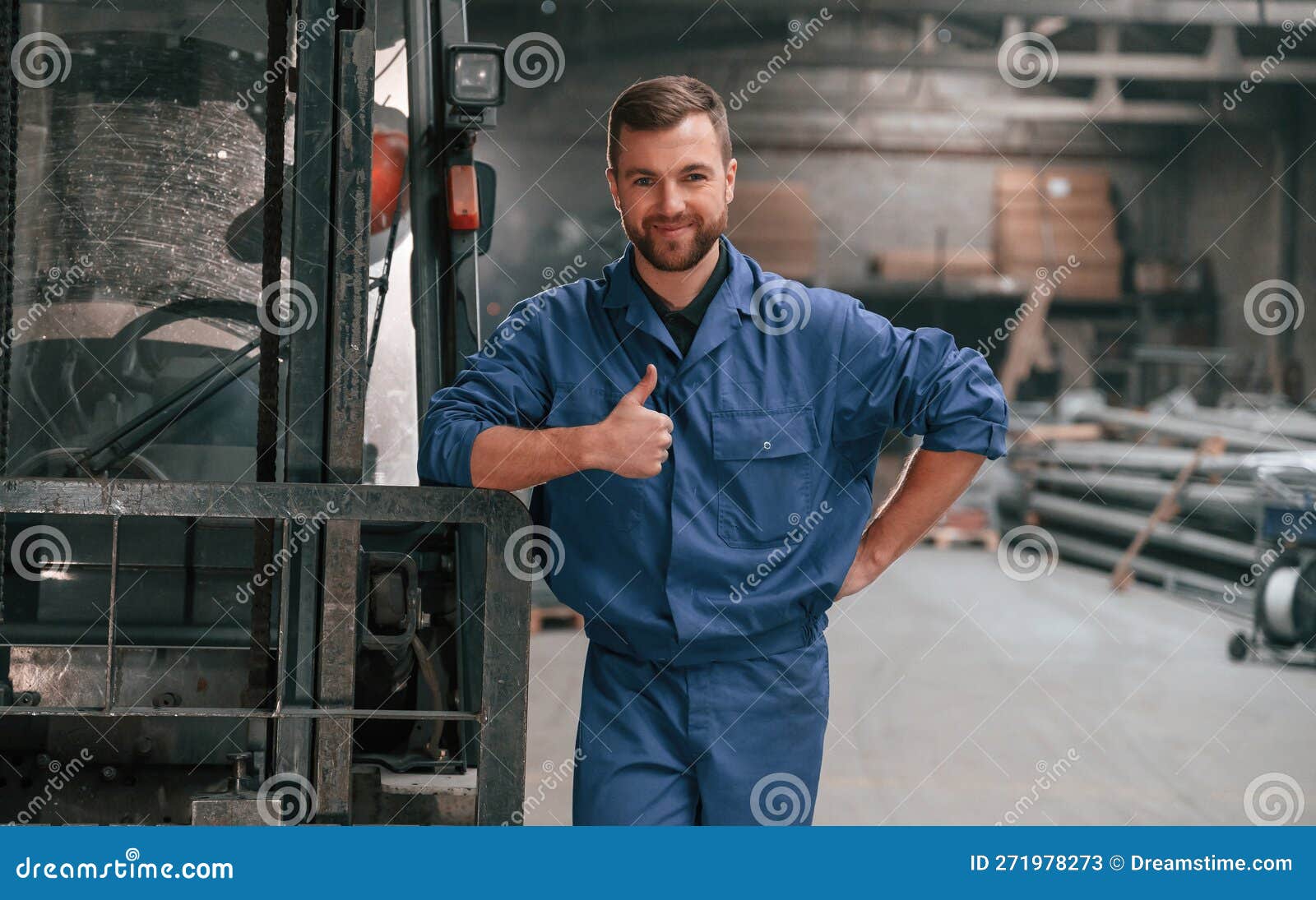 Leaning on the Forklift. Factory Worker in Blue Uniform is Indoors ...