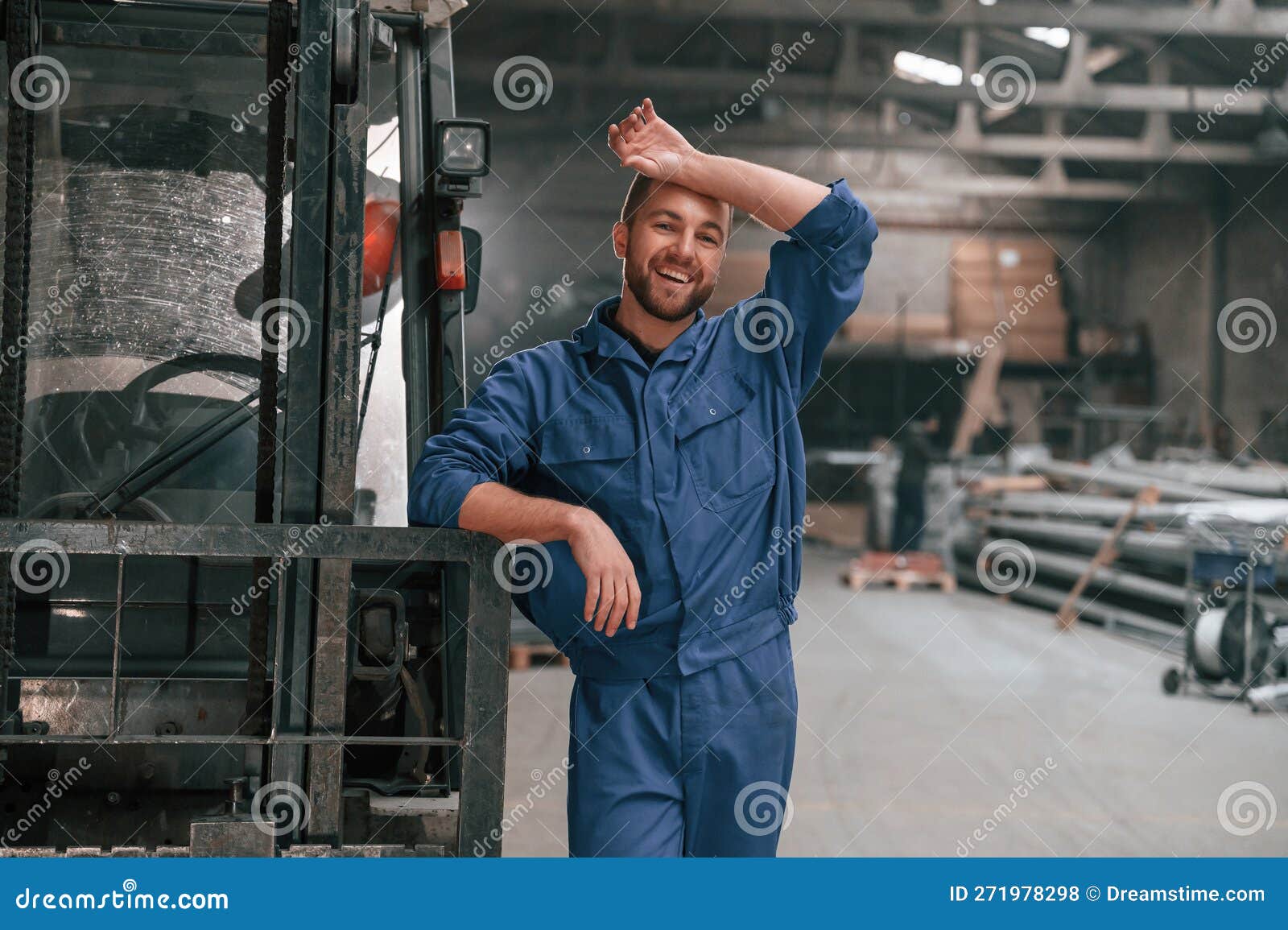 Leaning on the Forklift. Factory Worker in Blue Uniform is Indoors ...