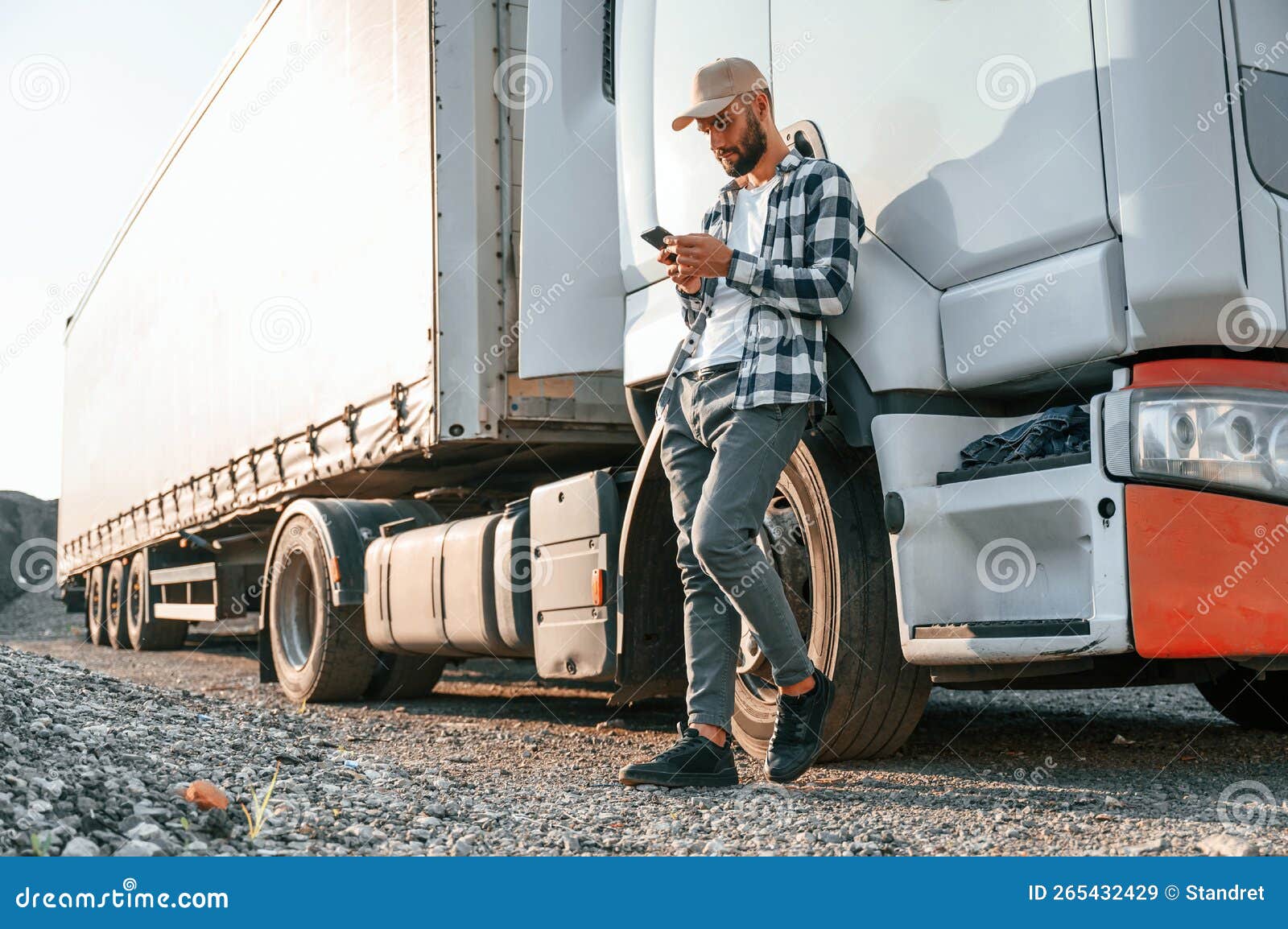 Leaning by the Vehicle and Using Phone. Young Truck Driver is at ...
