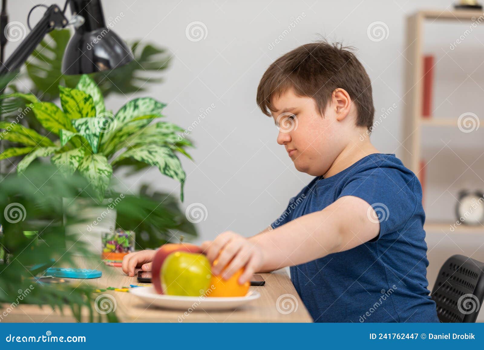 While Learning at Home, a Boy Reaches for an Apple. Stock Image - Image ...