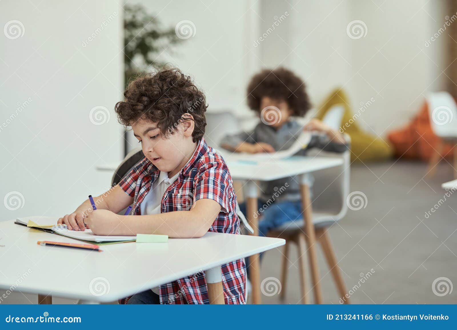 Learning Process. Busy Little School Boy Using Pen For Writing In ...