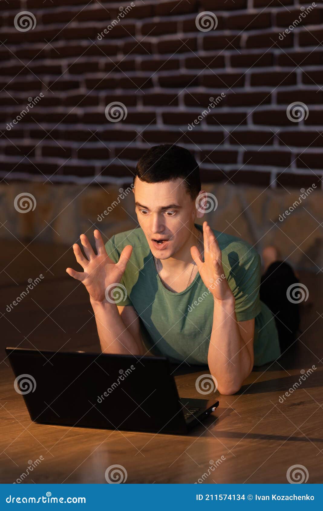 A Man Laying Down on the Floor Look at Laptop Screen Communicating ...