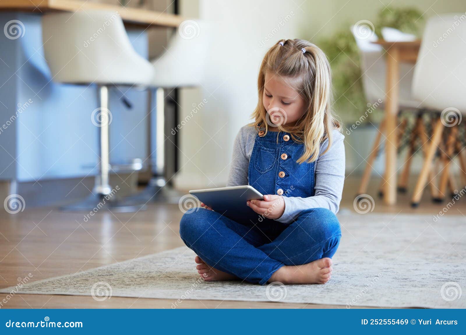 Learning about Technology. a Little Girl Using a Digital Tablet at Home ...