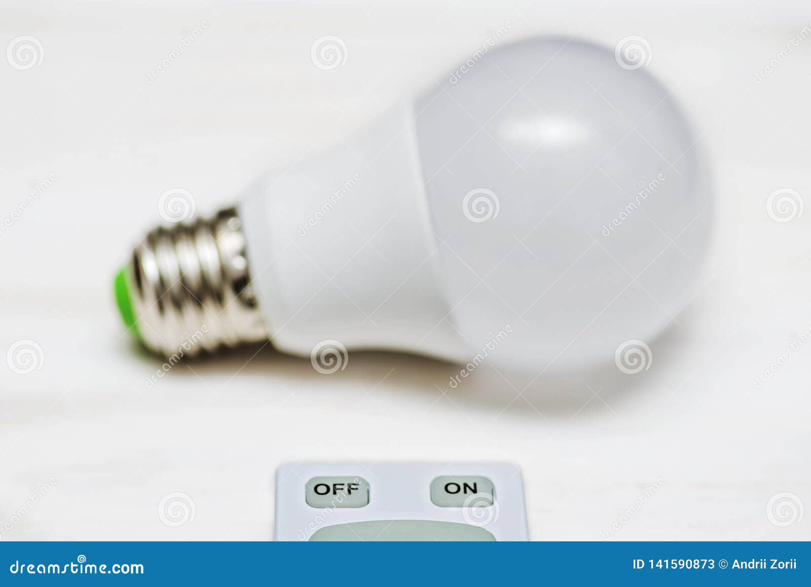 LED Light Bulb and Remote Control with Buttons on and Off on a White ...