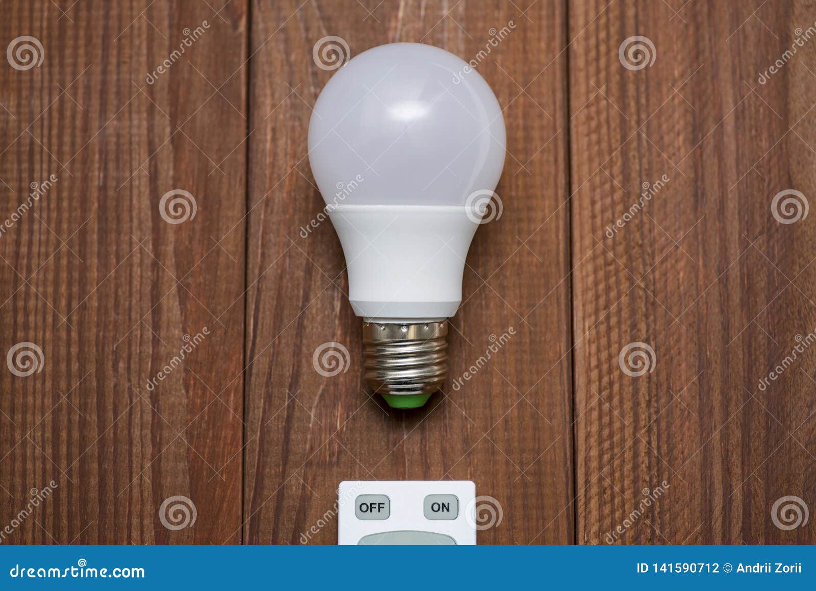 LED Light Bulb and Remote Control with Buttons on and Off on a Wooden ...