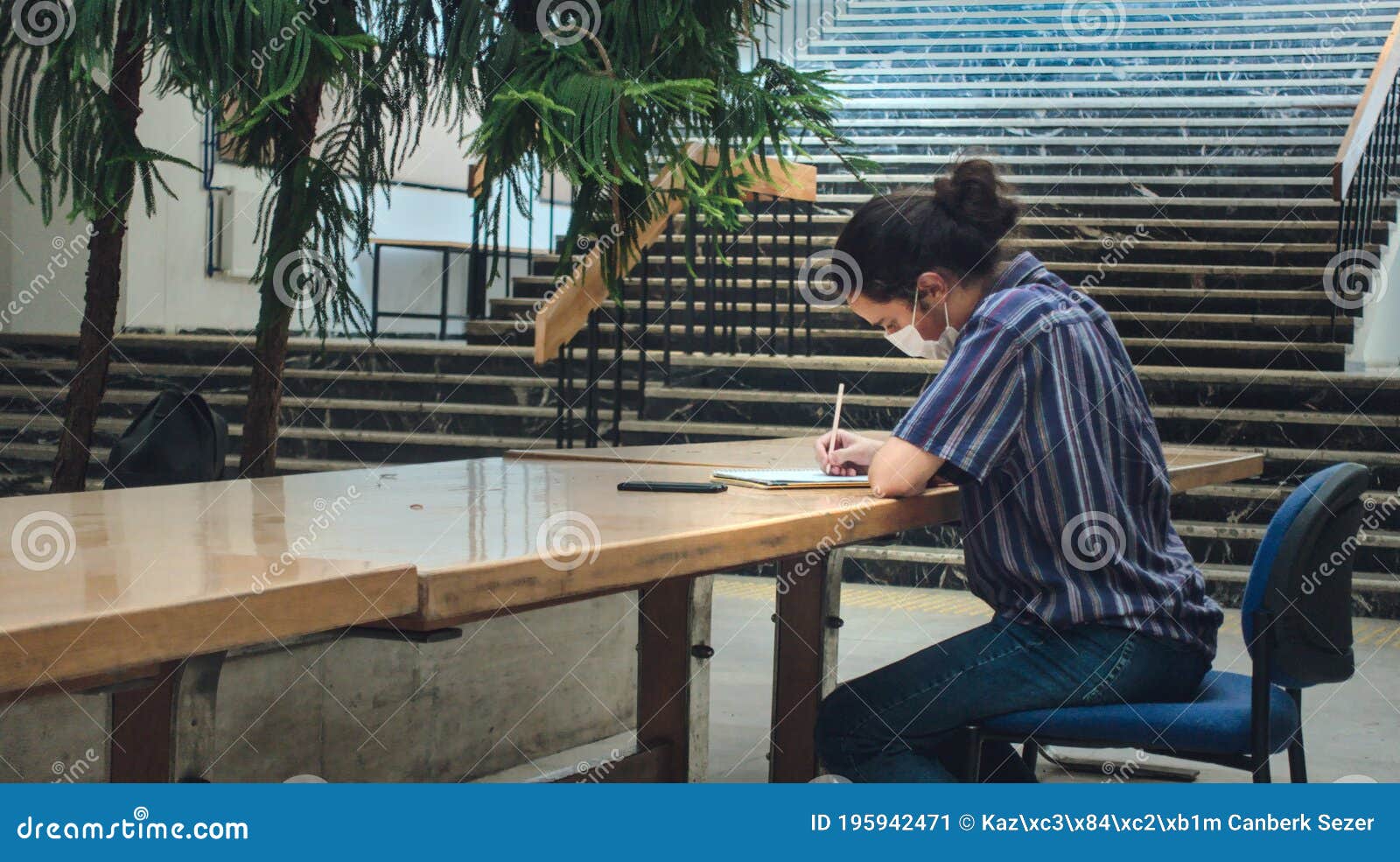 Left Angle Young College Student Taking Notes in the Library Alone ...