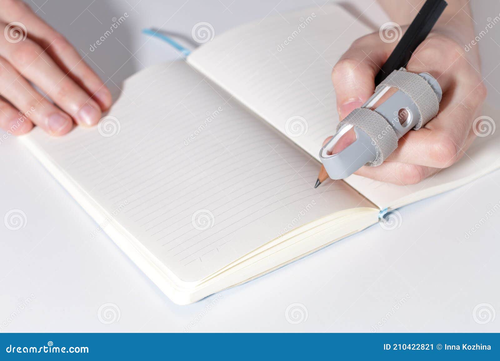 Left-handed Man with a Plastic Splint on an Index Finger Writing in a ...