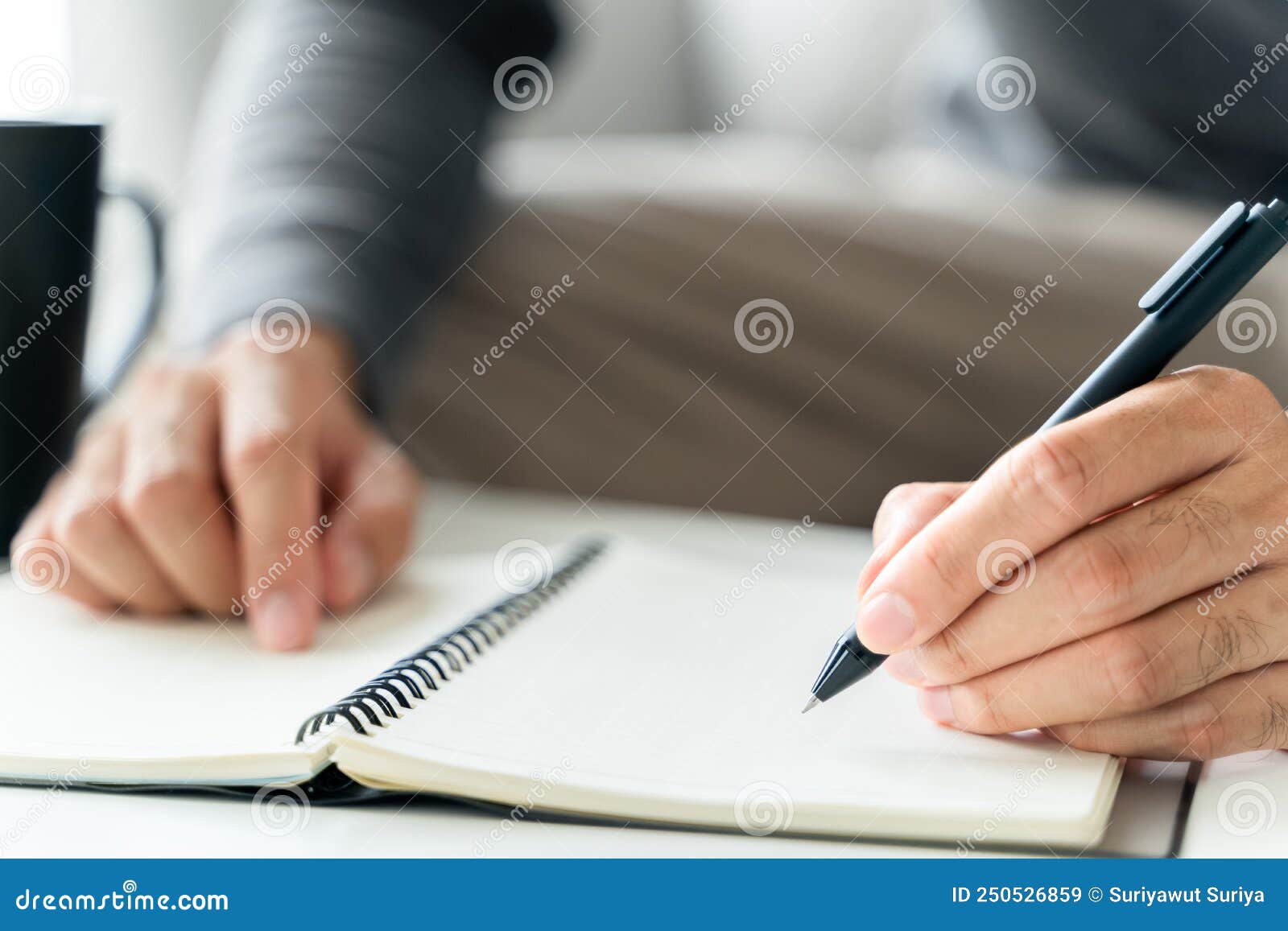 Left Handed Man Writes in a Notebook on the Table Stock Image - Image ...