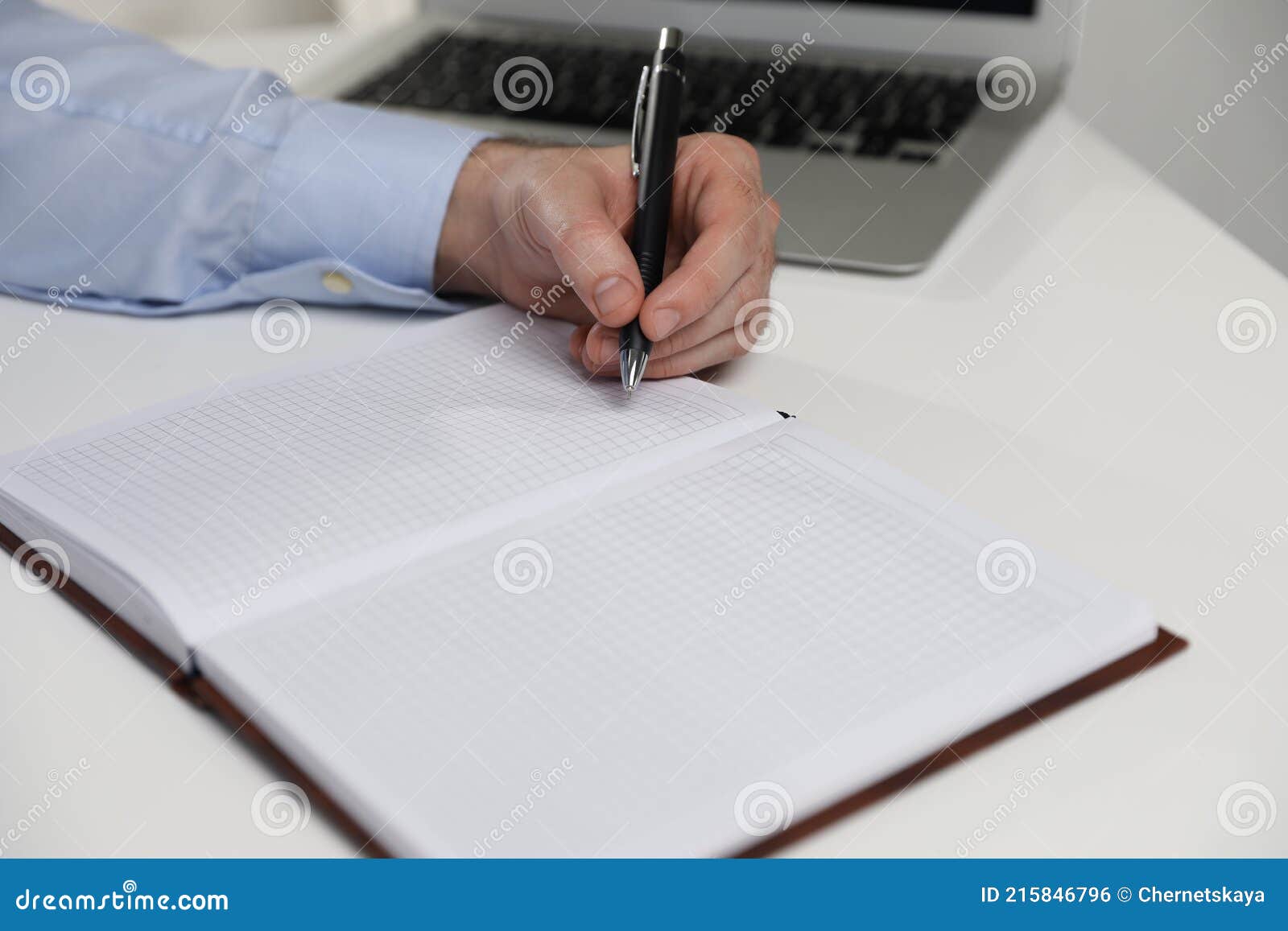 Left-handed Man Writing in Notebook at White Table, Closeup Stock Photo ...