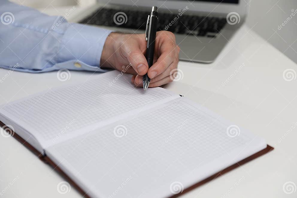 Left-handed Man Writing in Notebook at White Table, Closeup Stock Photo ...