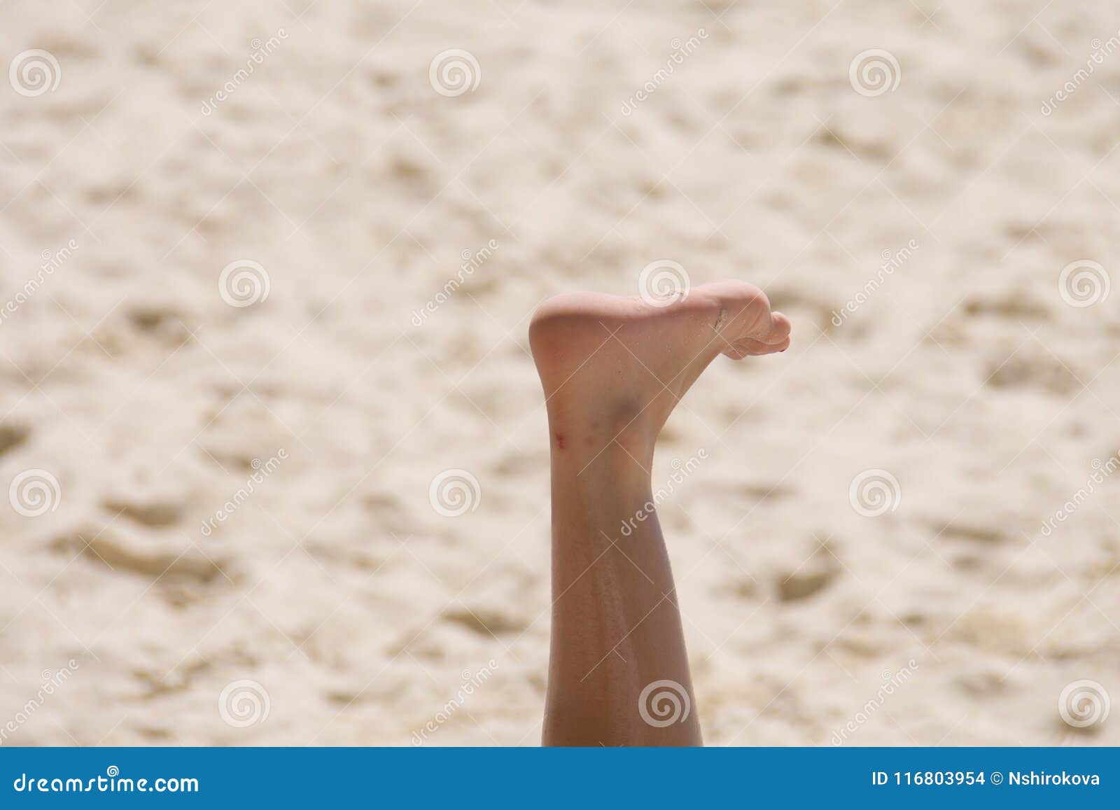 Leg of a woman on the sand stock photo. Image of water - 116803954