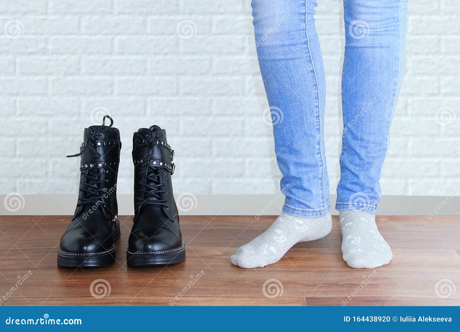 Legs Of A Girl In Blue Jeans And Socks Next To A Pair Of Black Boots ... Legs Of A Girl In Blue Jeans And Socks Next To A Pair Of Black Boots ...