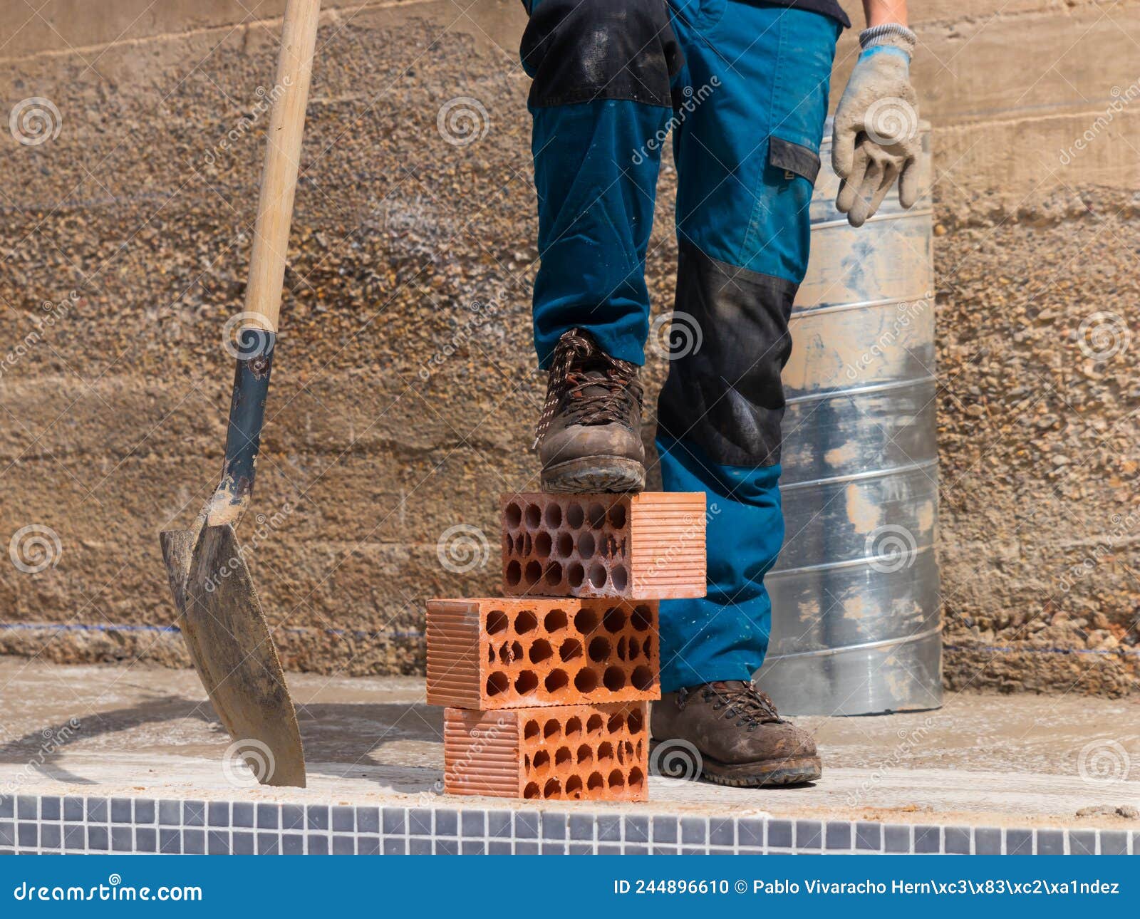 Legs of Worker with Foot on Bricks and Shovel in Hand Vertically in ...