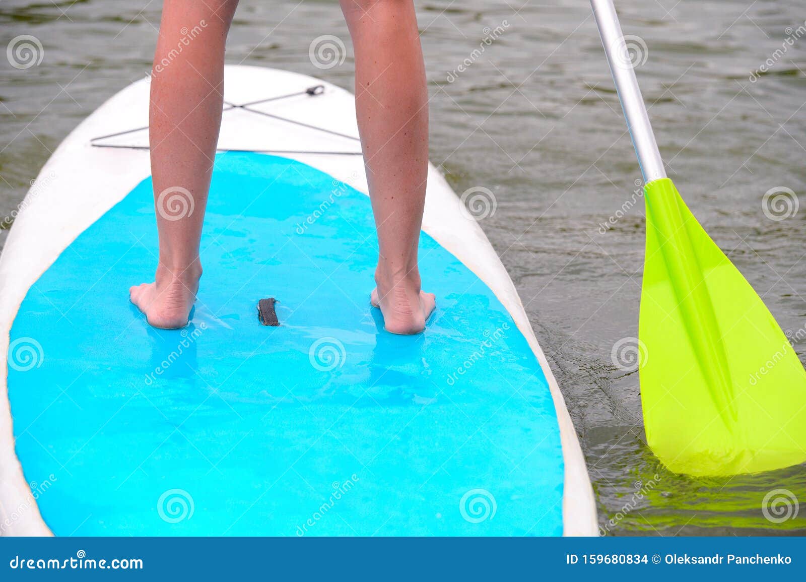 Legs of a Young Woman Standing on a Paddle Board on the Surface of the ...