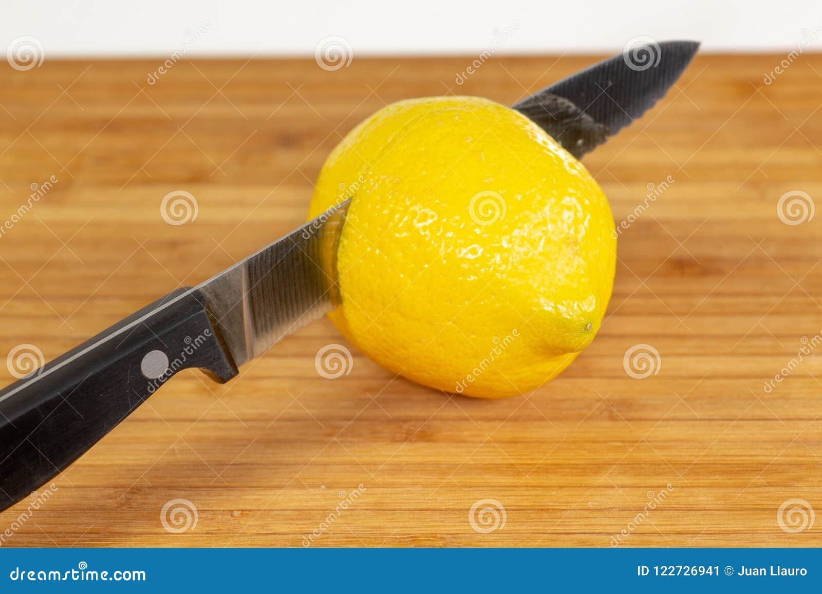 Lemon Being Sliced in Half on a Cutting Board on a Kitchen Table Stock ...