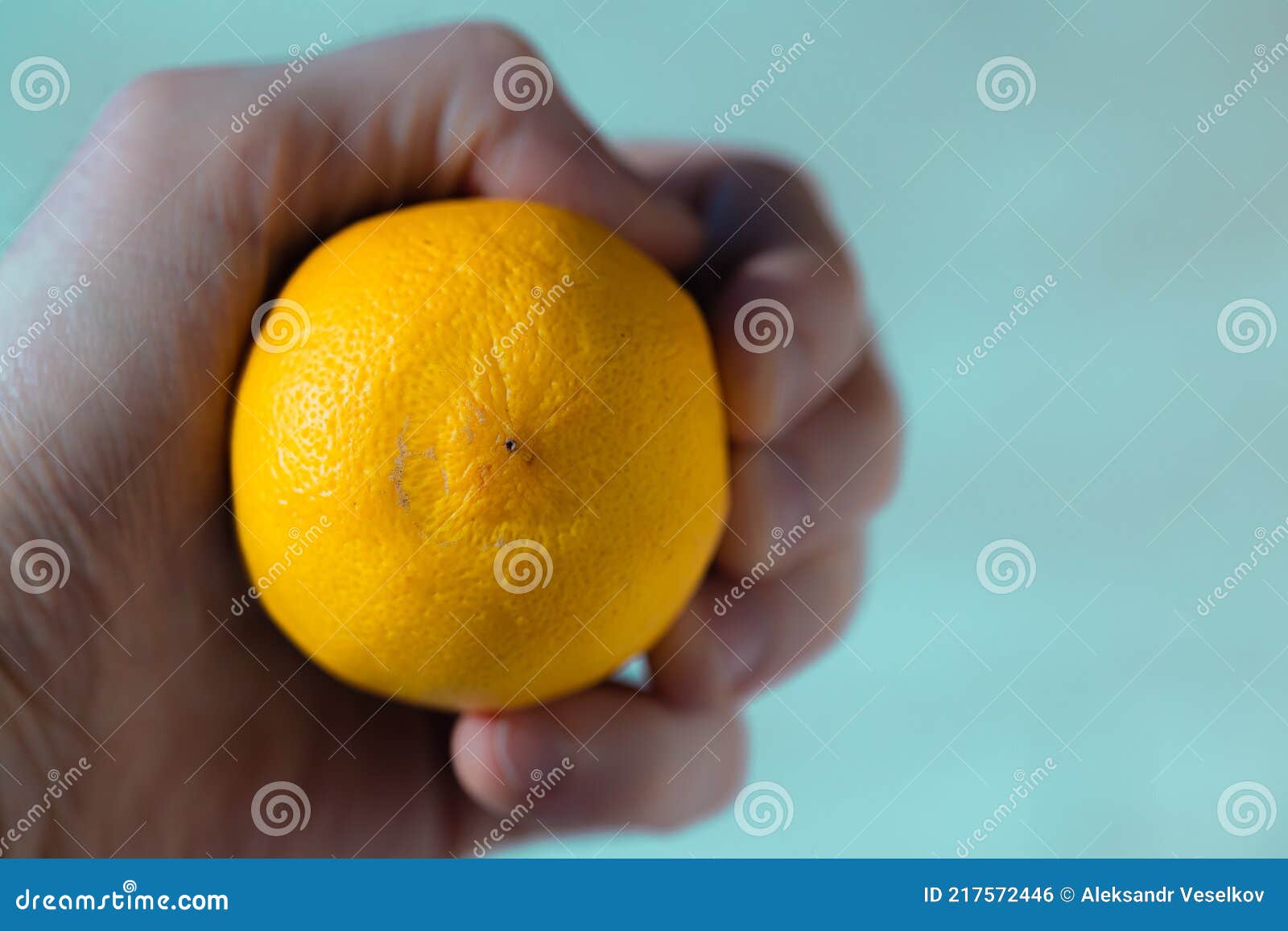 Lemon in Hand on a Gentle Blue Background. Compressed Citrus in the ...