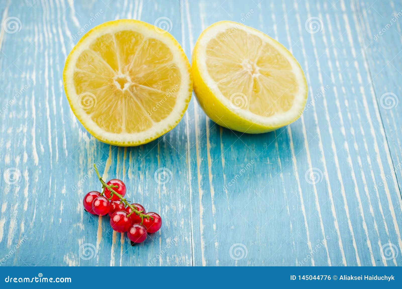 Lemon and Red Currant on a Blue Wooden Background/lemon and Red Currant ...