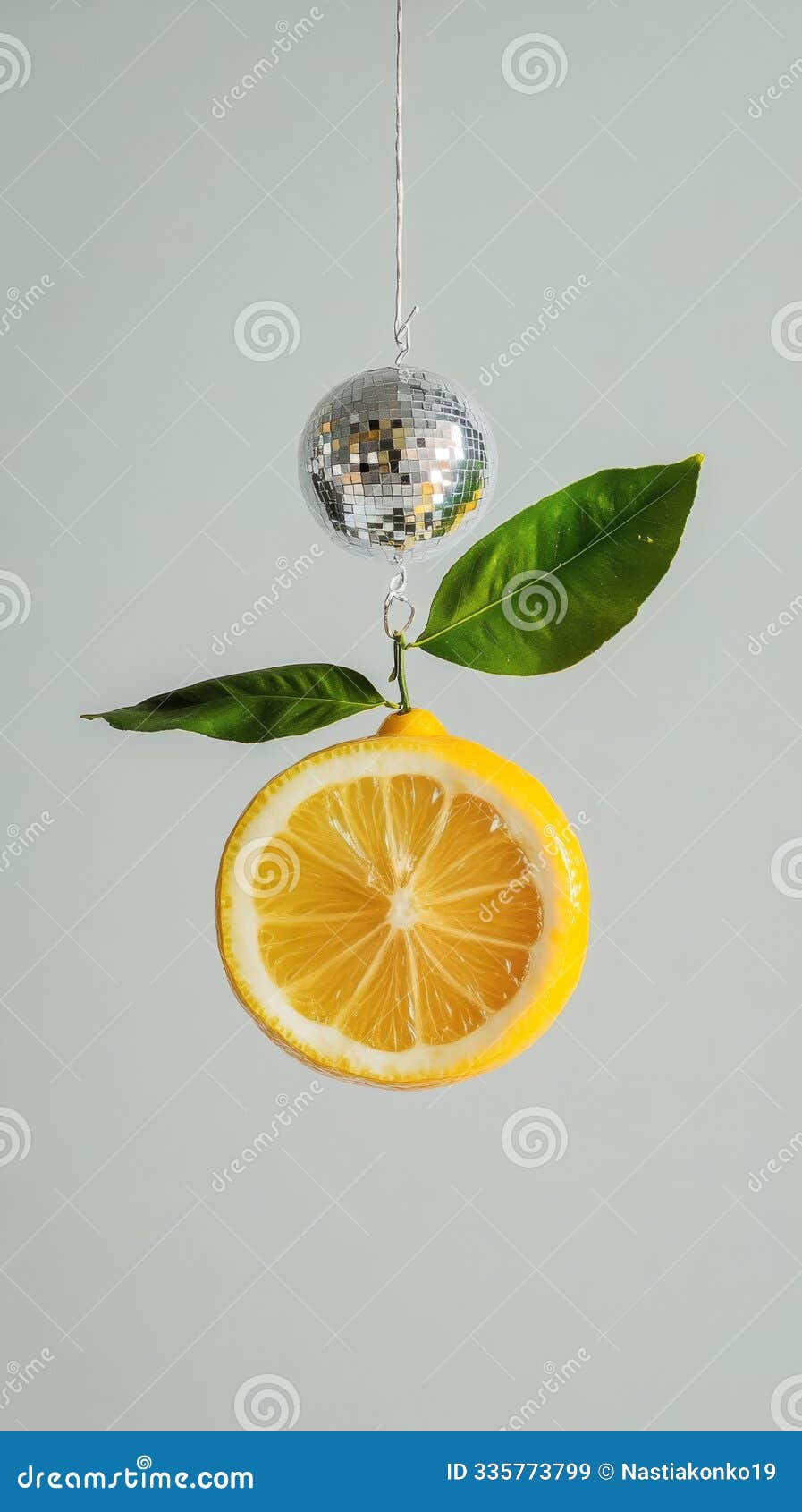Lemon Slice with Disco Ball and Green Leaves on Gray Background Stock ...