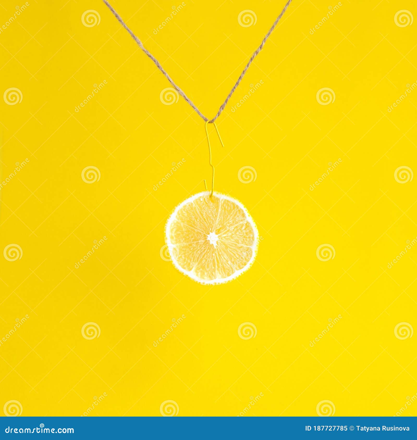 A Lemon Slice Hangs on a Rope on a Yellow Background Stock Image ...