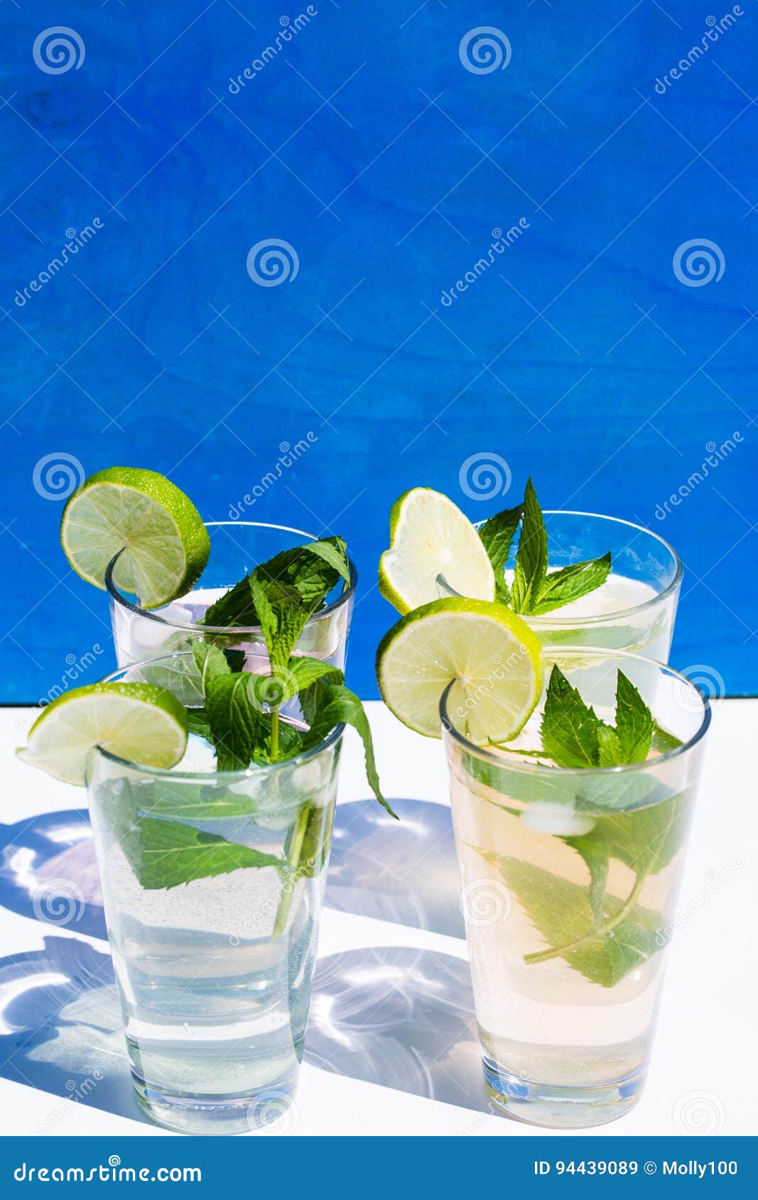 Lemonade Against Blue Background, with Mint and Lime Stock Image ...