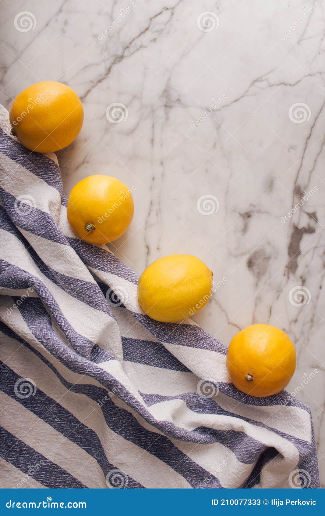 Lemons on a Blue and White Striped Fabric Against White Marble ...