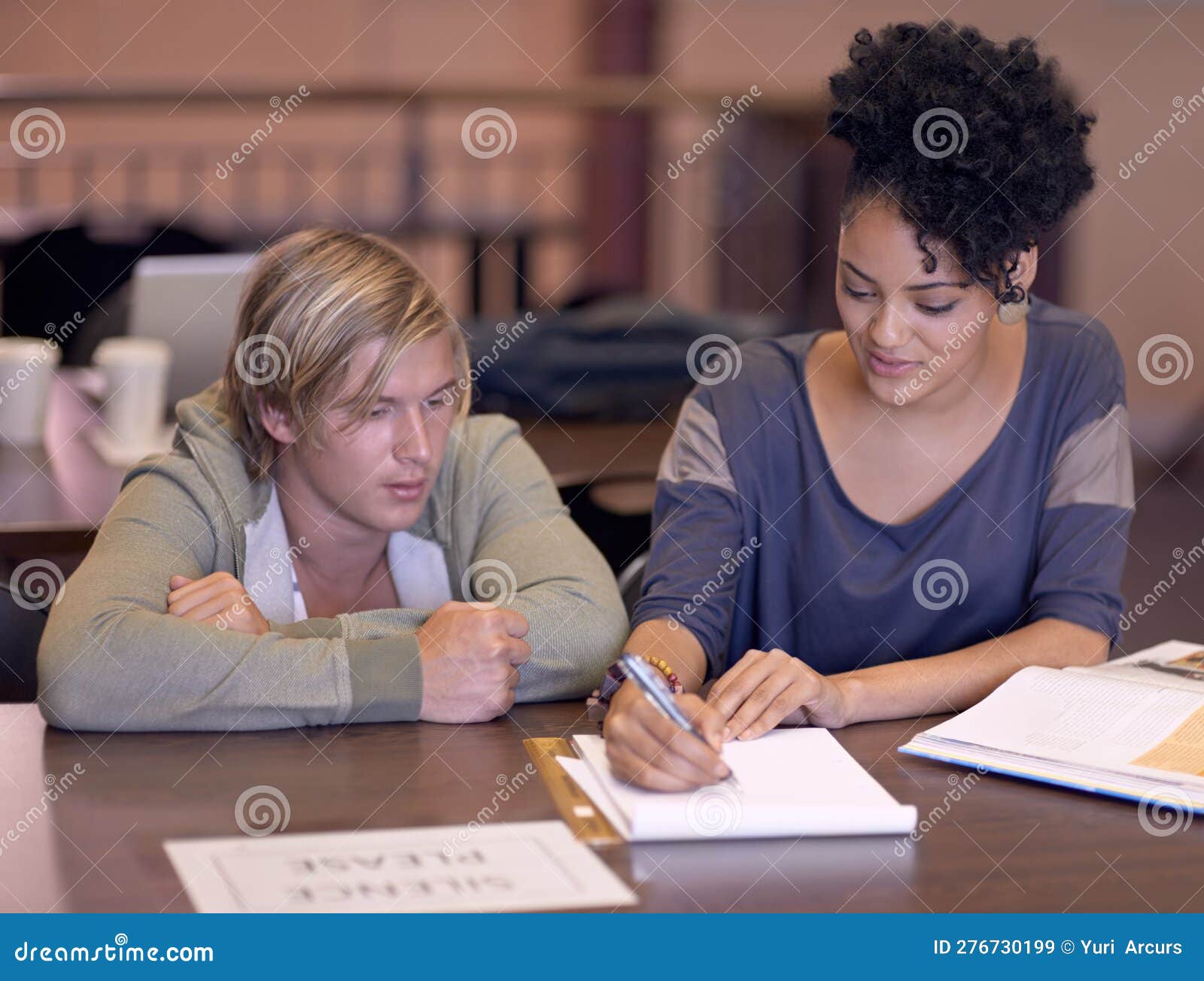 Lending a Helping Hand. Two Students Working Together and Writing Notes ...