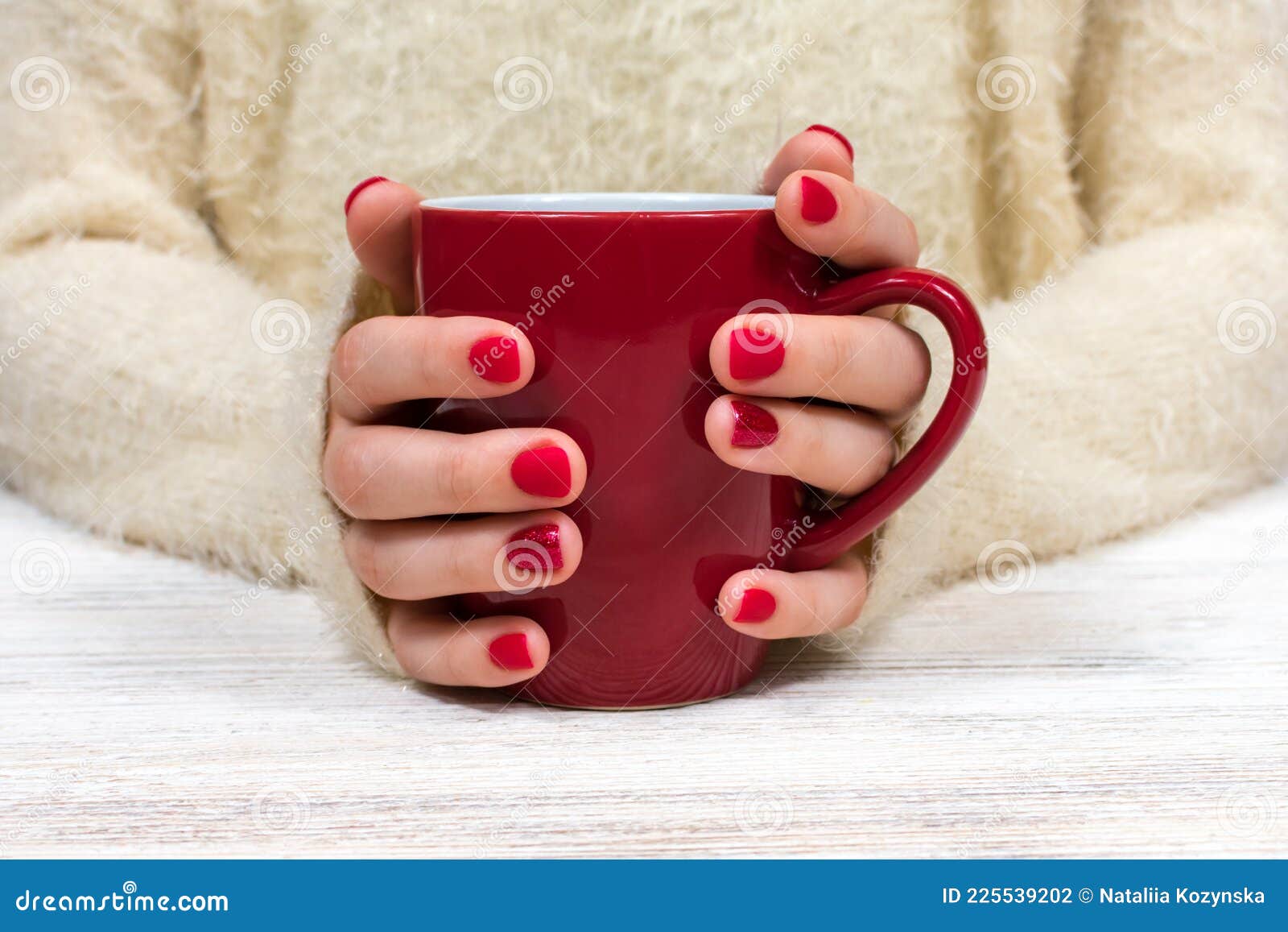 Les Mains Des Femmes Tiennent Une Tasse Rouge Sur Le Fond Dun Pull