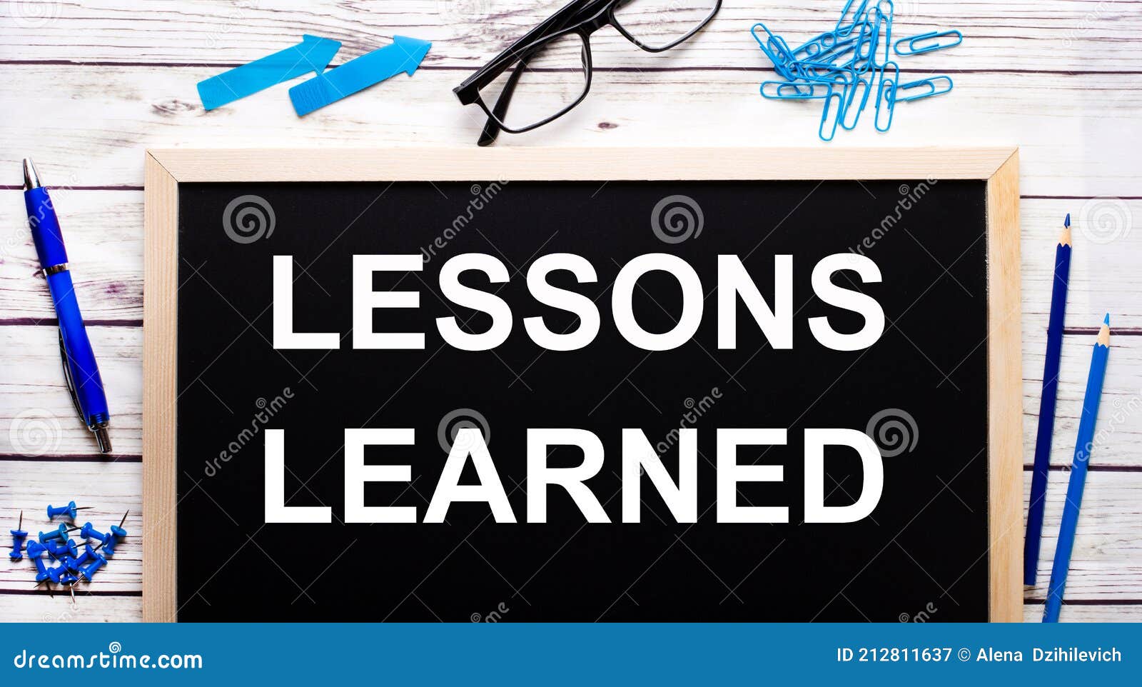 LESSONS LEARNED Written on a Black Note-board Next To Blue Paper Clips ...