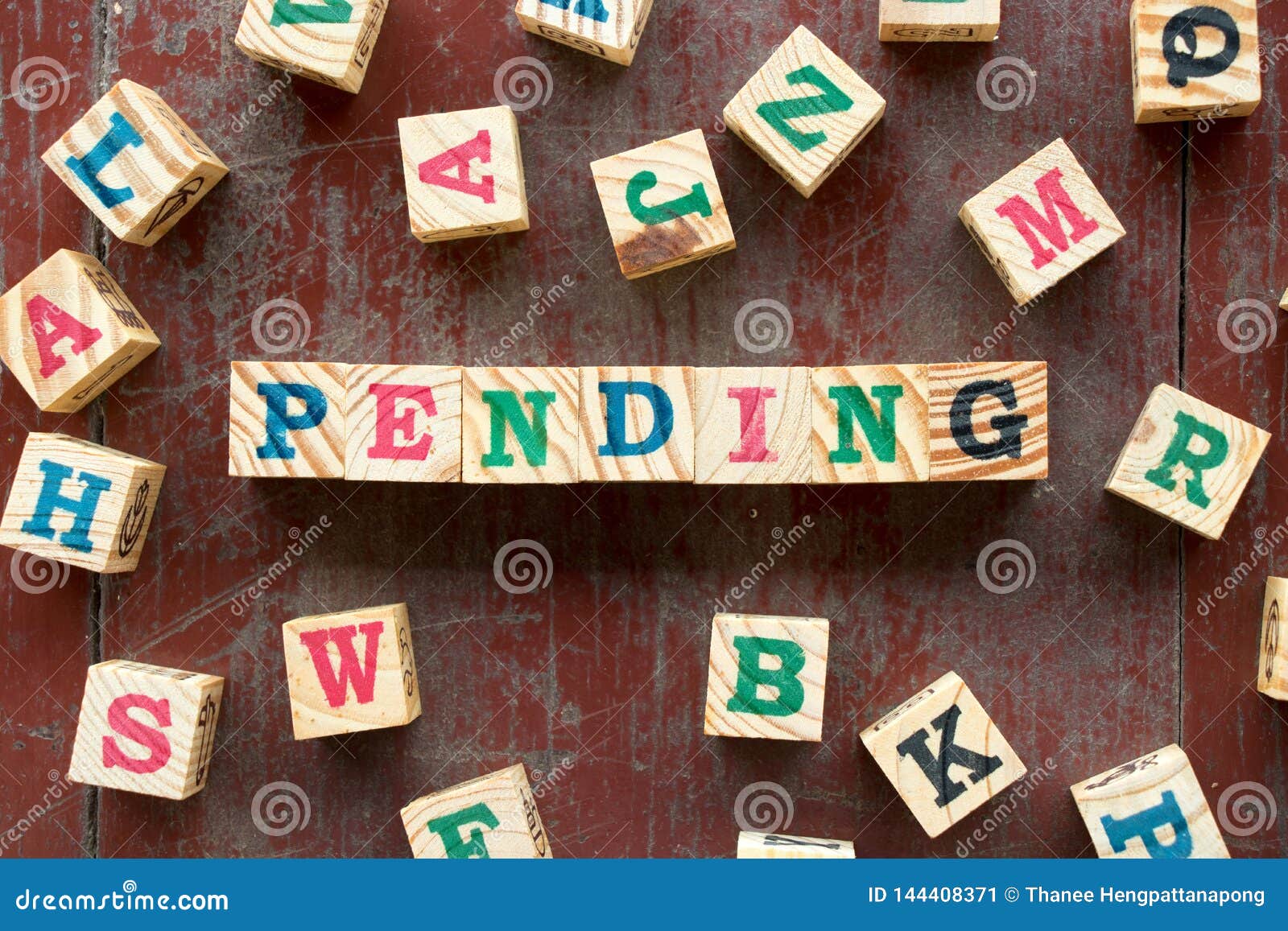 Letter Block in Word Pending with Another on Red Wood Background Stock ...