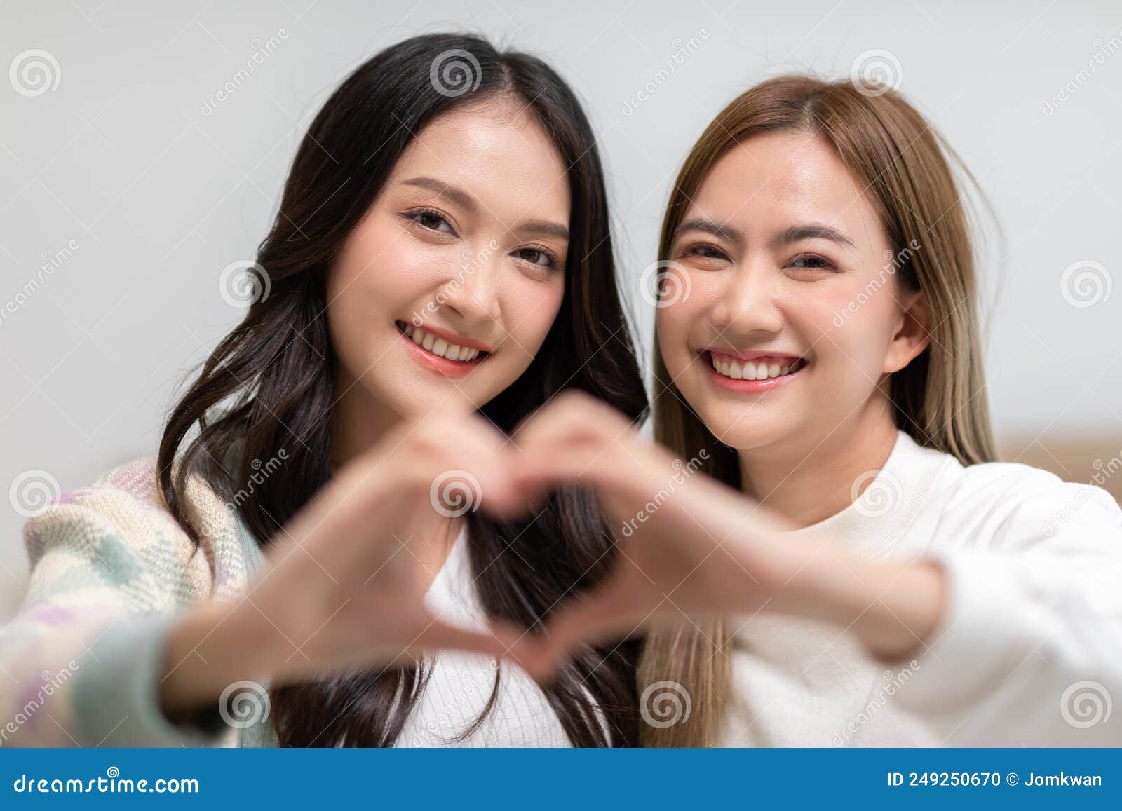 Lgbtq Asian Lesbian Couple Making Heart Shape Sign Hug And Smiling With