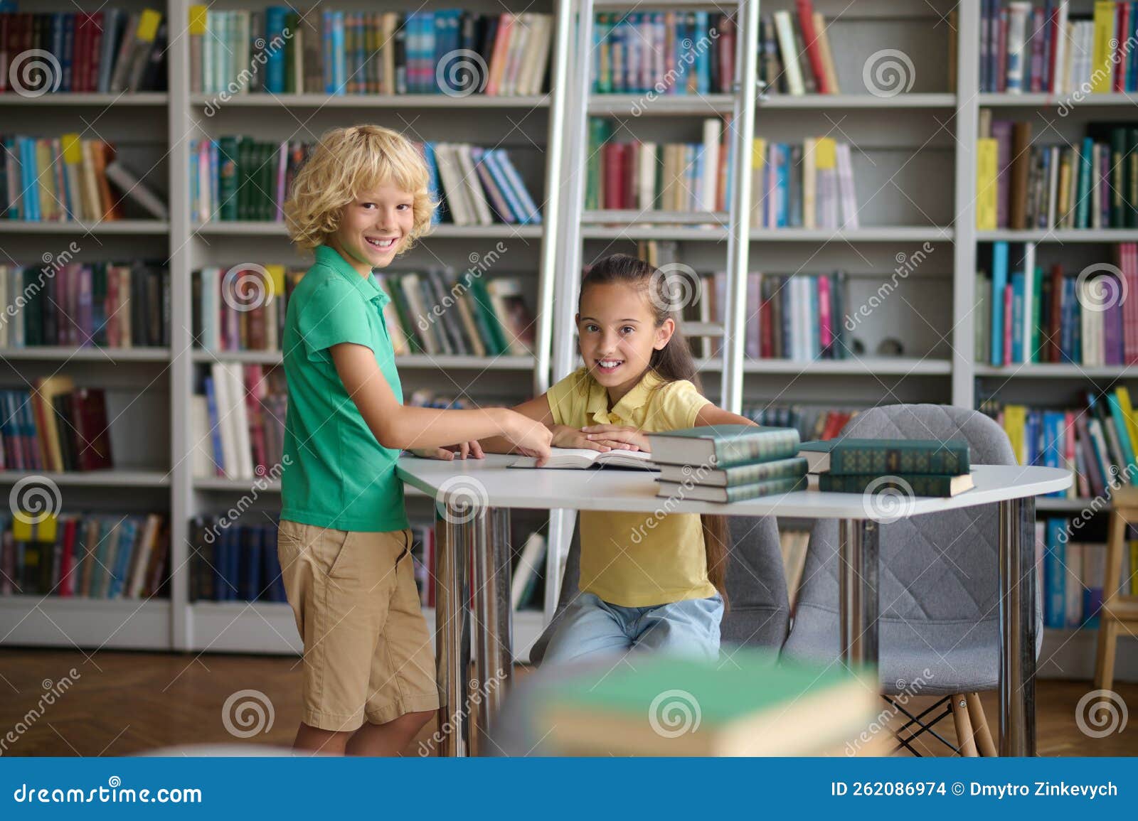 Classmates Reading Together in a School Library Stock Photo - Image of ...