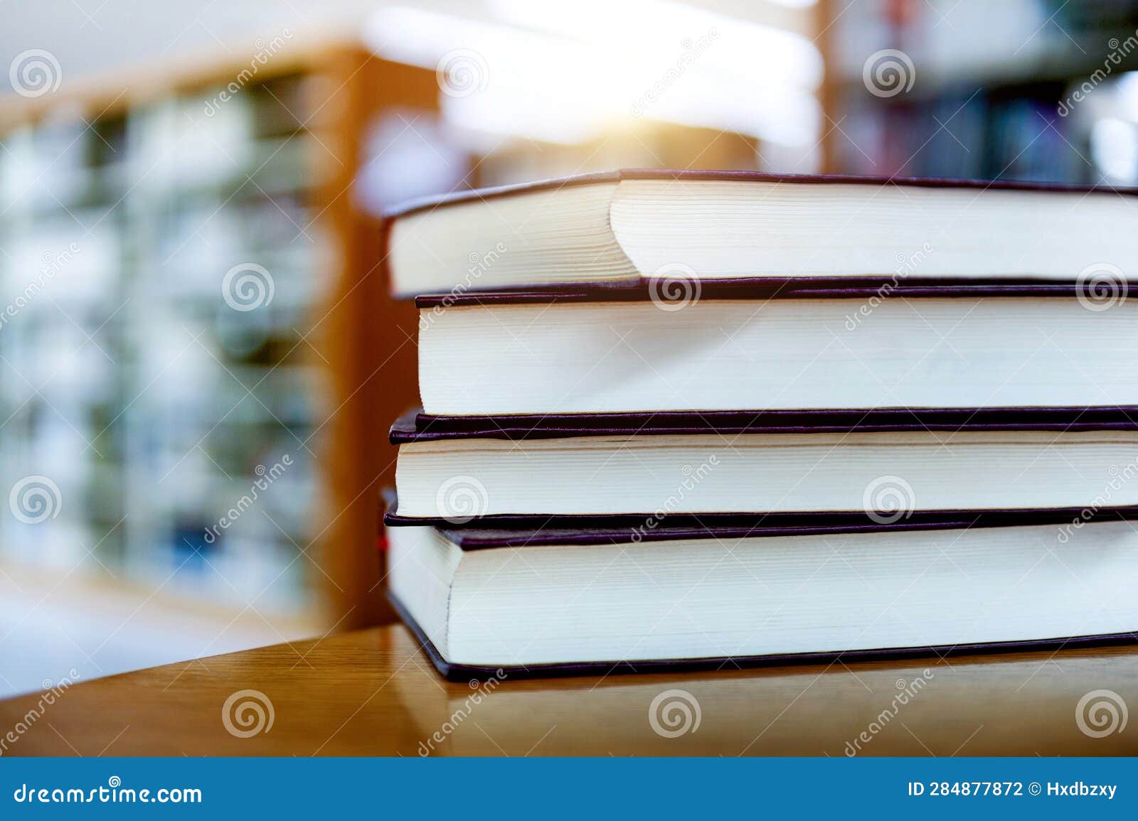 Four books stacked on desk stock photo. Image of bookcase - 284877872
