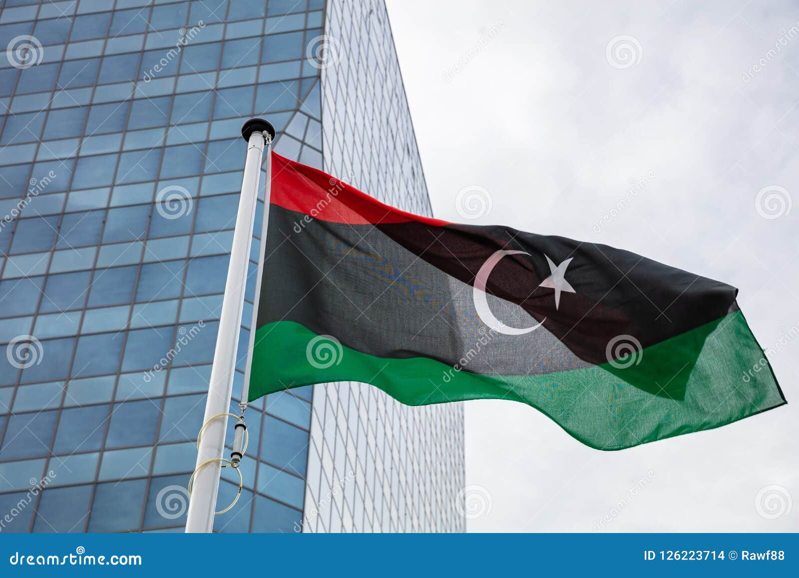 Libya Flag on a Pole Waving, Modern Office Building Background Stock ...