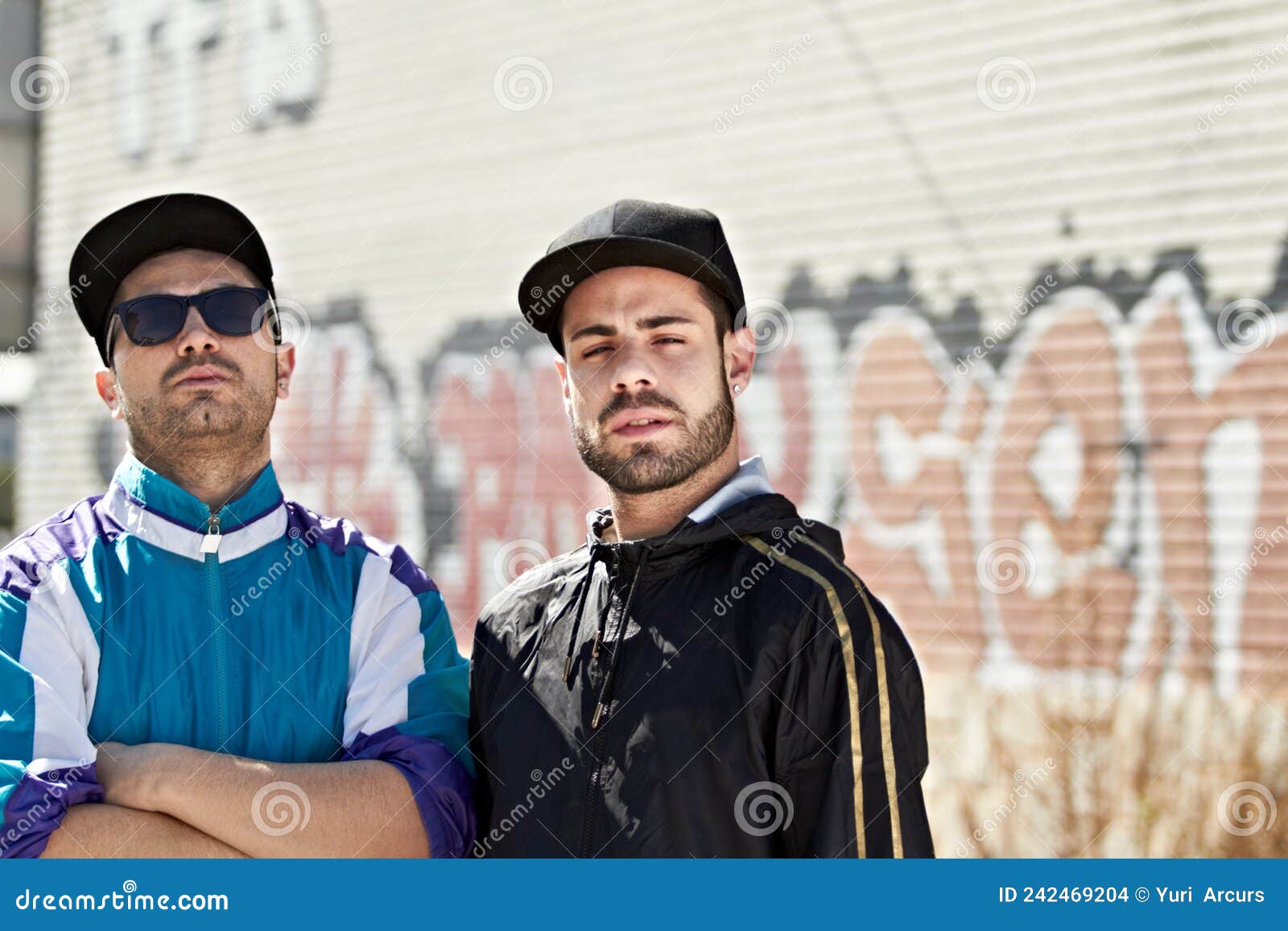 Life on the Street. Two Serious Men Standing in Front of a Graffiti ...
