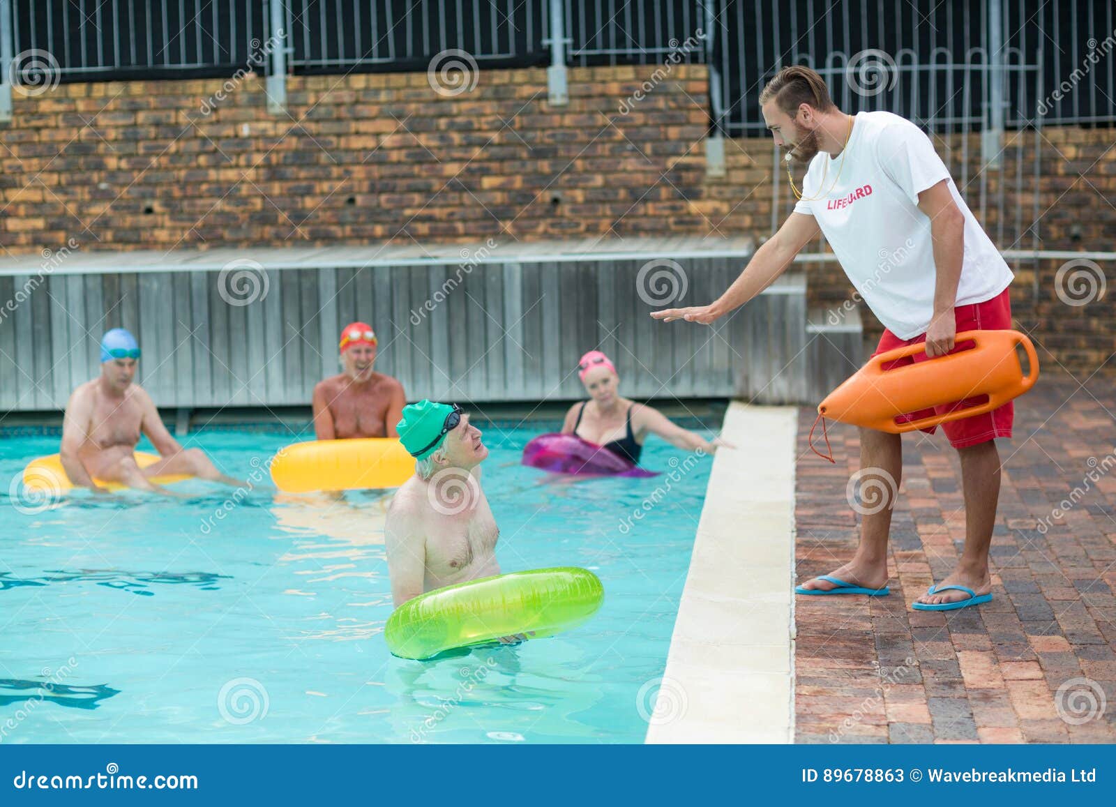 Lifeguard Helping Swimmers at Poolside Stock Image - Image of caucasian ... Lifeguard Helping Swimmers at Poolside Stock Image - Image of caucasian ...
