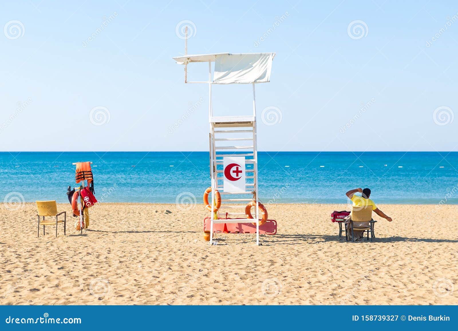 Lifeguard Next To the Tower on the Beach Sitting on a Chair Back ...