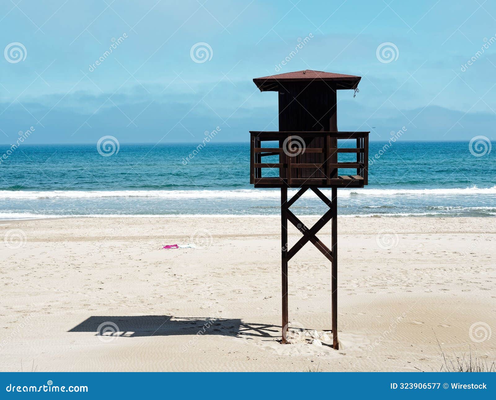 Lifeguard Tower on an Empty Beach with a Blue Sky and Calm Ocean Waves ...