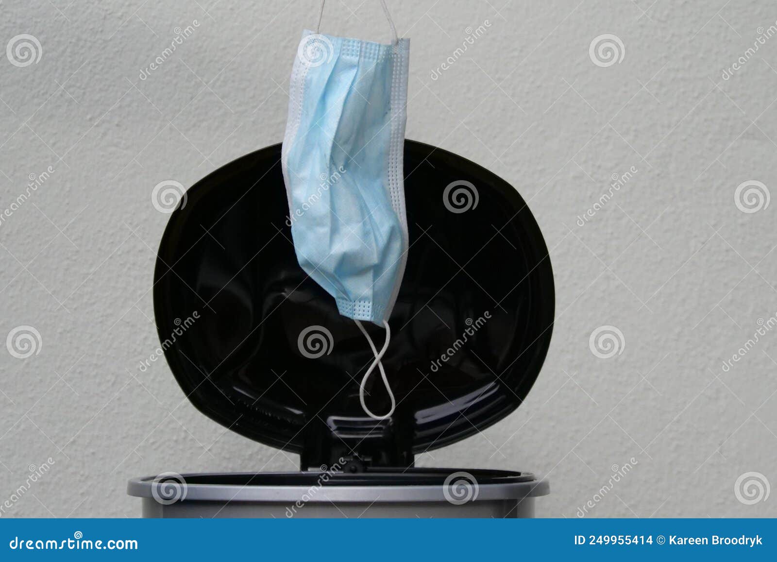 Light Blue Disposable Face Mask Hanging Above Bin before Being Thrown ...