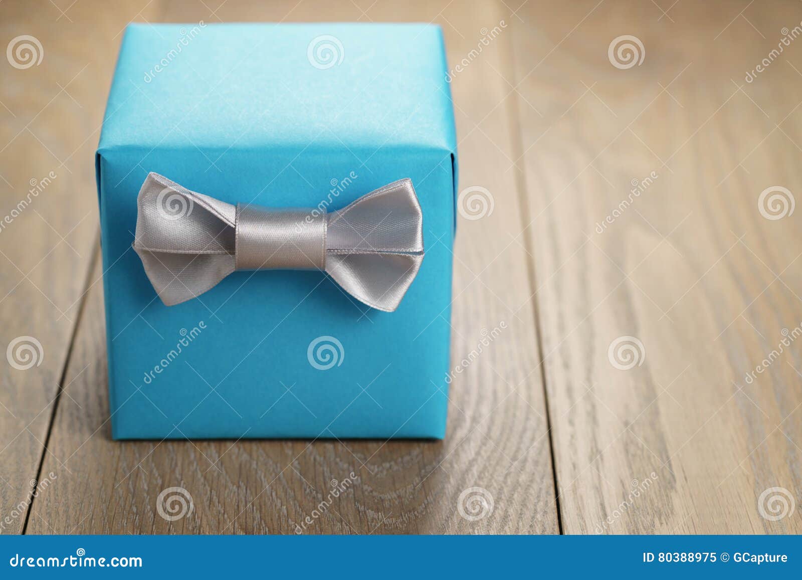 Light Blue Gift Box with Minimalistic Silver Ribbon Bow on Wooden Table ...