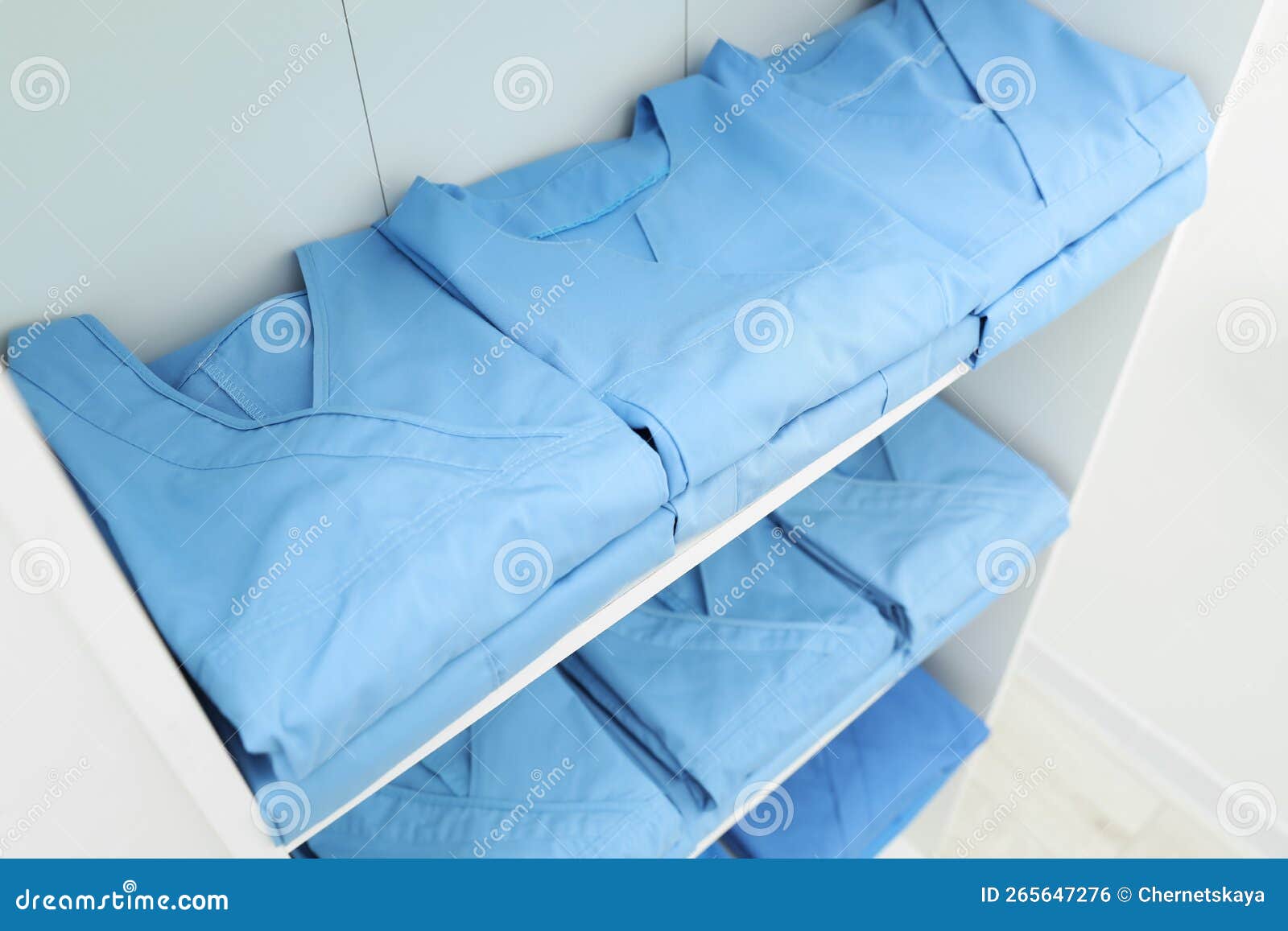 Light Blue Medical Uniforms on White Rack, Above View Stock Photo ...