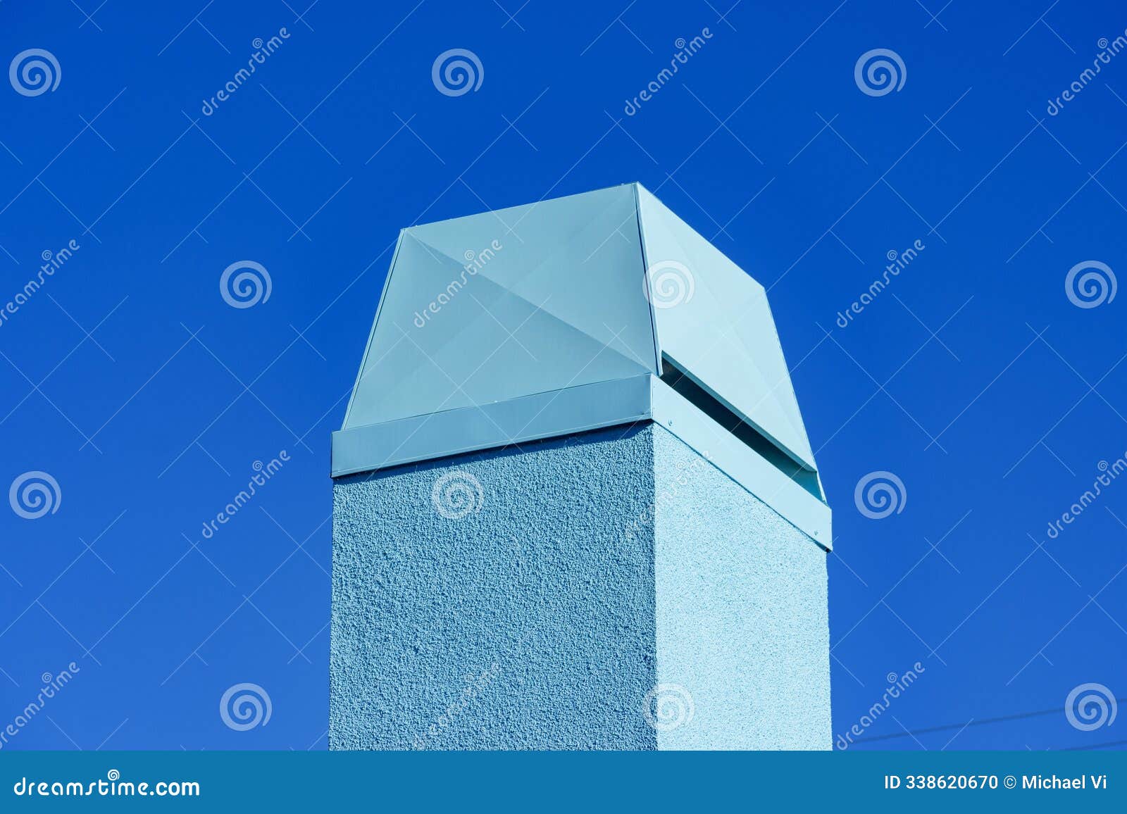 A Light Blue Stucco Chimney with a Modern, Metallic Vent on Top Stock ...
