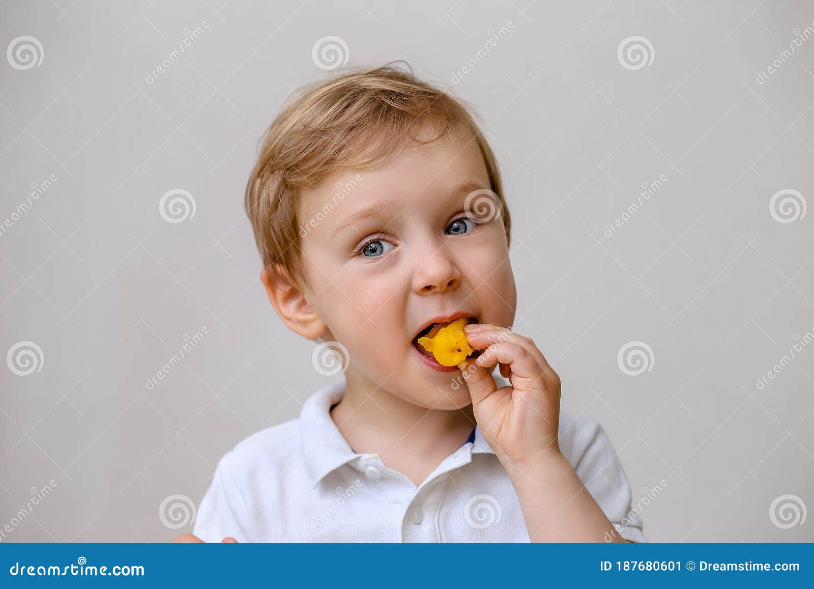 A Light Boy Todler Eats an Orange Fruit. Stock Image - Image of infant ...