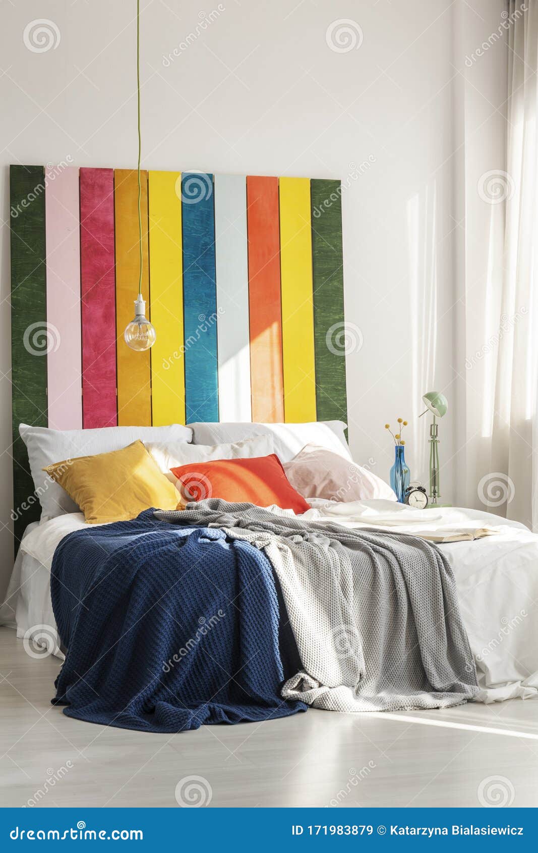 Light Bulb Above Cozy Bed with Pillows and Blankets in Bright Bedroom ...